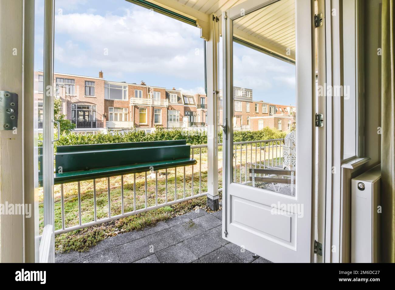 the outside of a house with an open door and green bench on the front ...