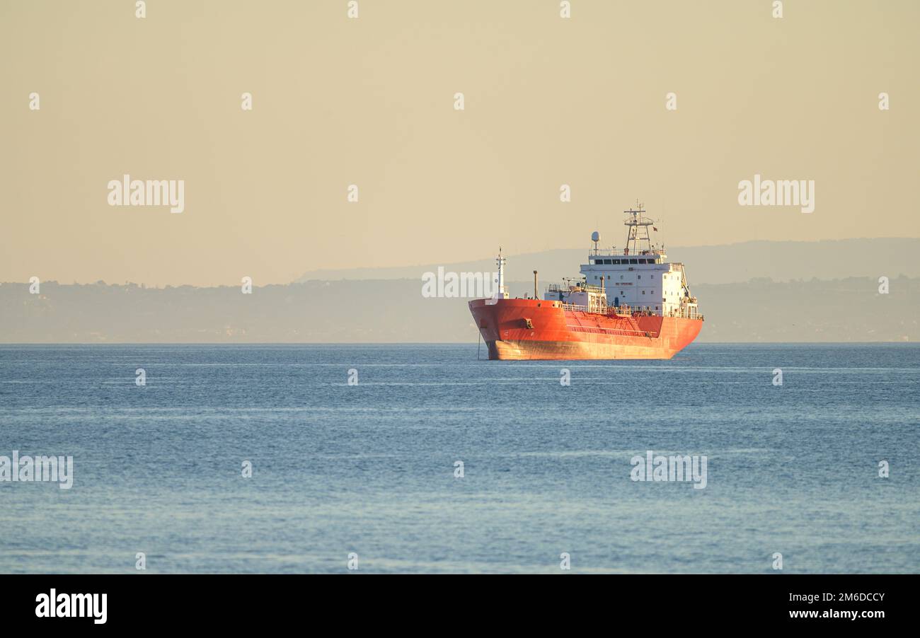 LPG tanker ship anchored in the Strait of Messina at sunset, Sicily ...