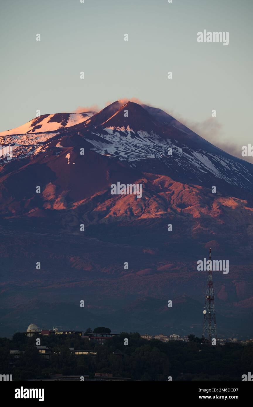 Snow covered Mount Etna volcano and Catania city center at sunset, from ...