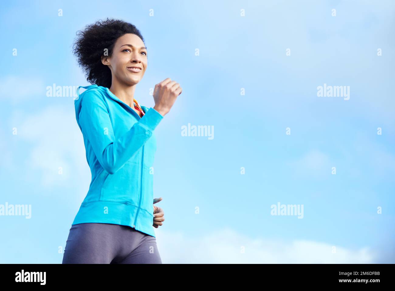 The perfect day for a run. a young woman jogging on a clear day Stock ...