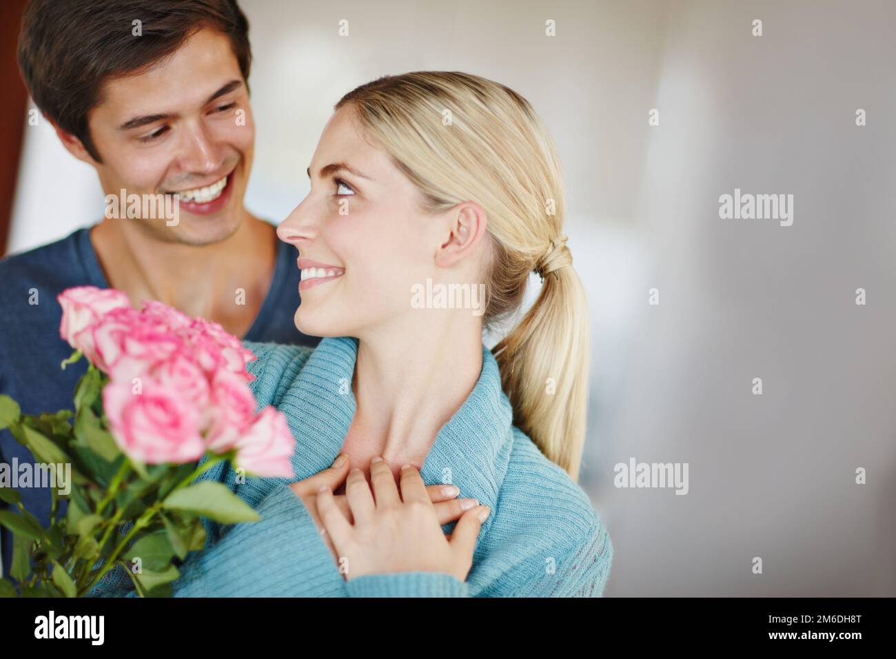 Their love is in bloom. an affectionate young man giving his beautiful ...