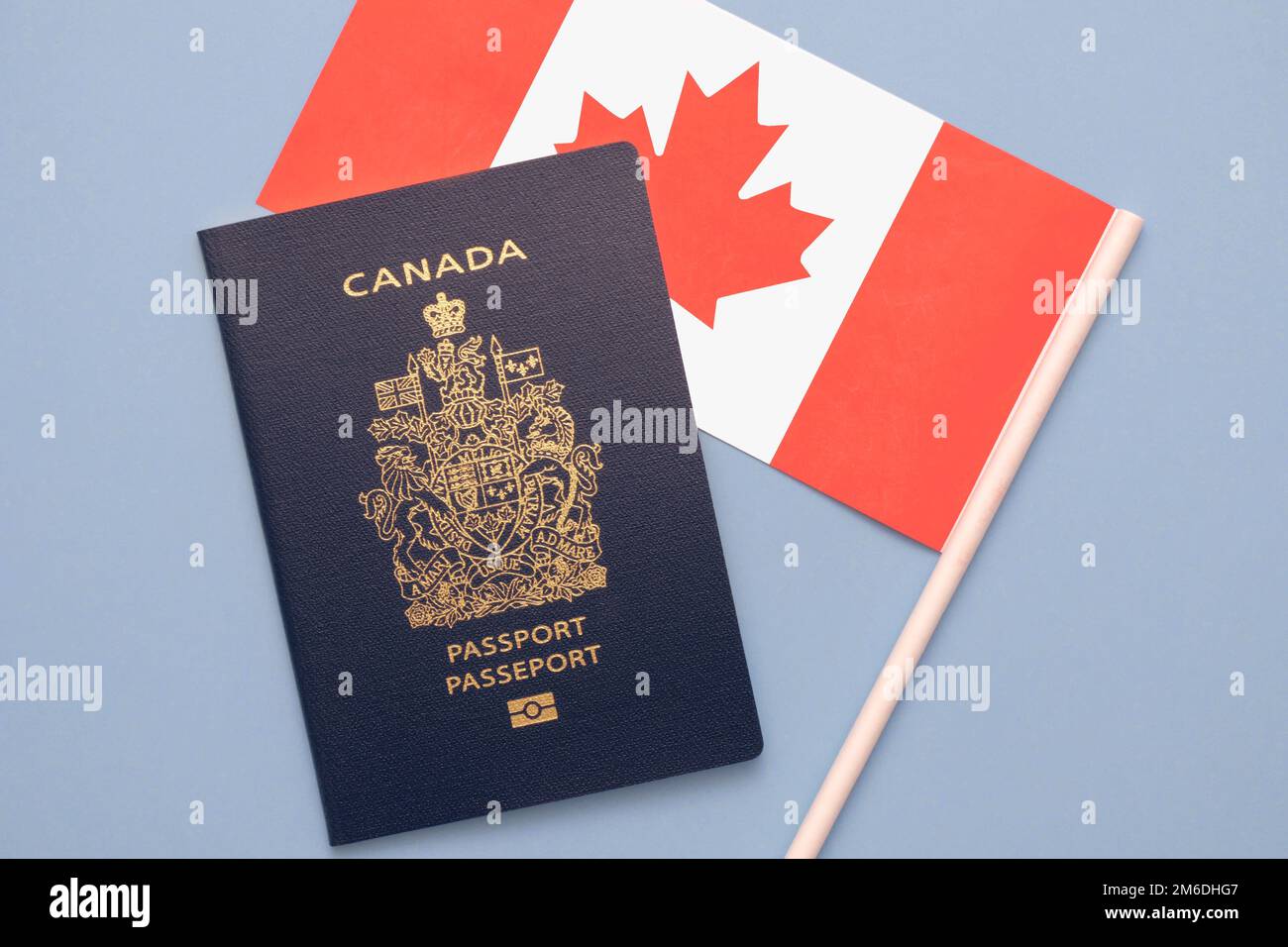 A Canadian passport on a Canadian Flag against a solid light blue ...