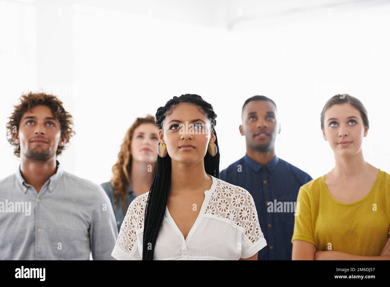 Young and forward thinking. a group of work colleagues looking up at ...