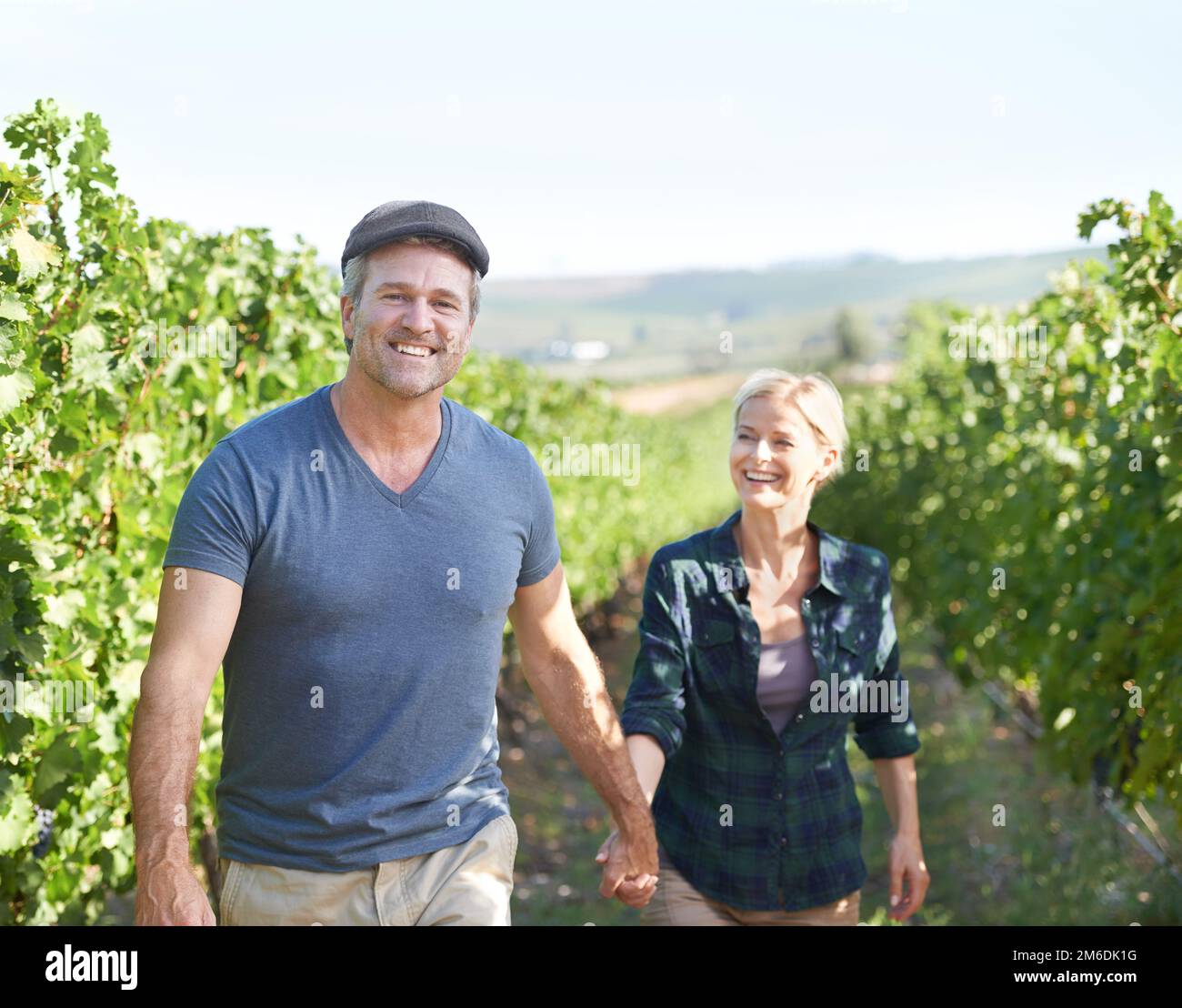 Exploring the vineyard together. A happy mature couple walking through ...