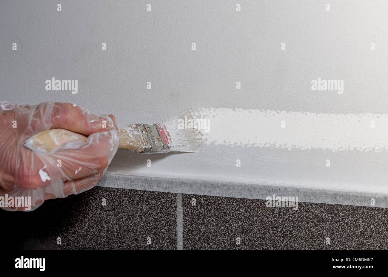 Painting the wall white with a brus Stock Photo - Alamy