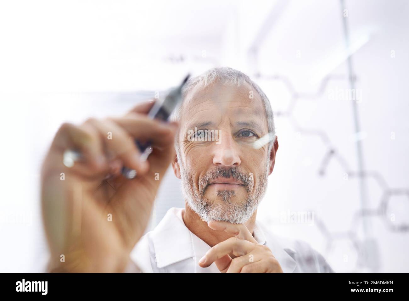 Chemistry is his area of expertise. a mature male scientist drawing the ...