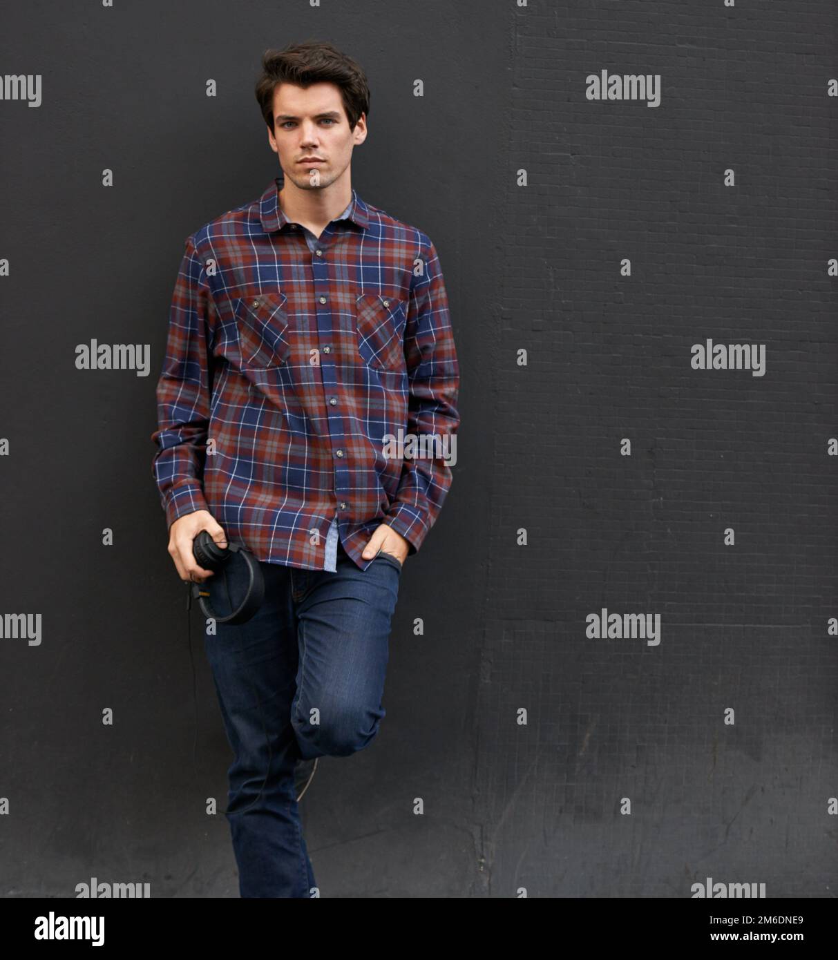 Laid back in plaid. a handsome young man standing outdoors with his ...