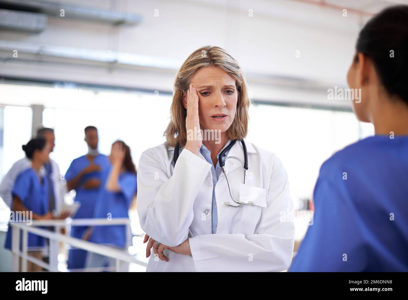 Its been a long shift at the hospital. an overworked doctor talking to ...