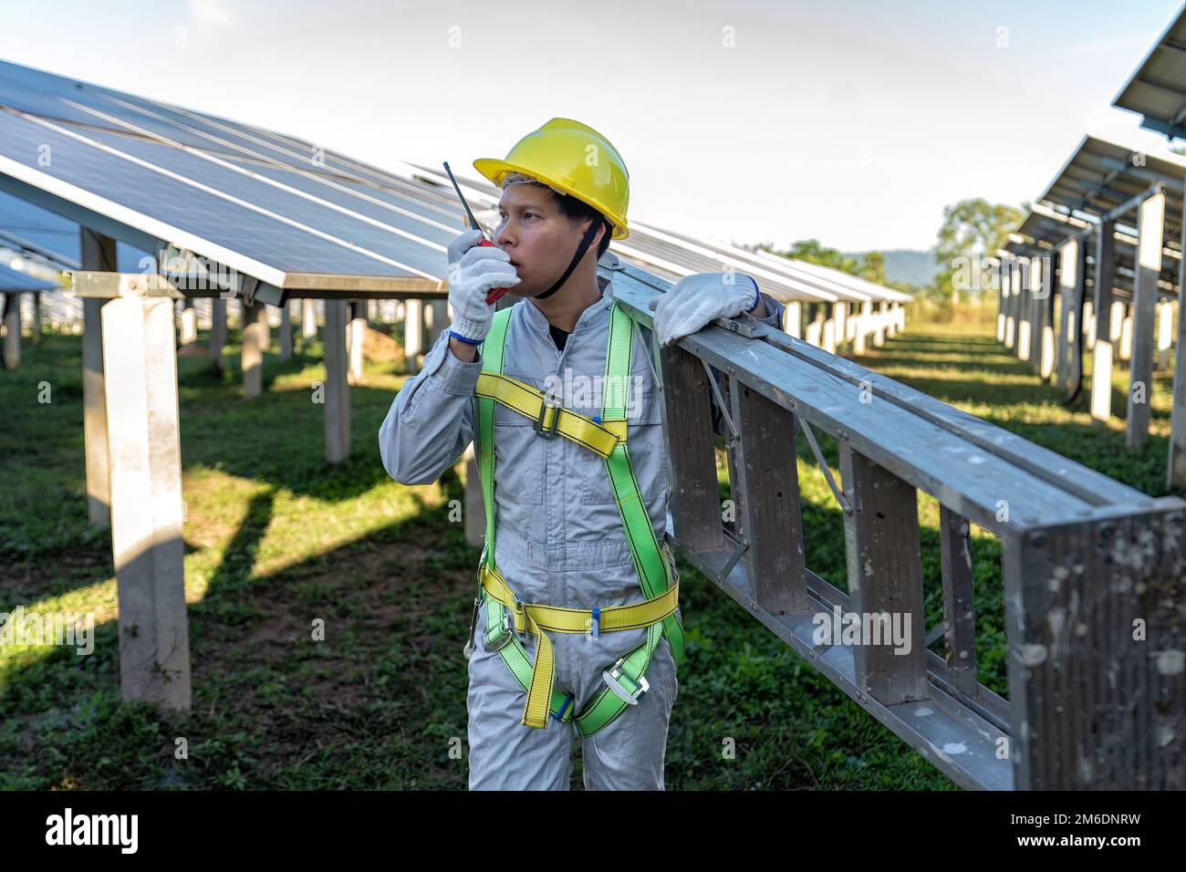 Maintenance engineer hold step ladder work at village Solar farm ...