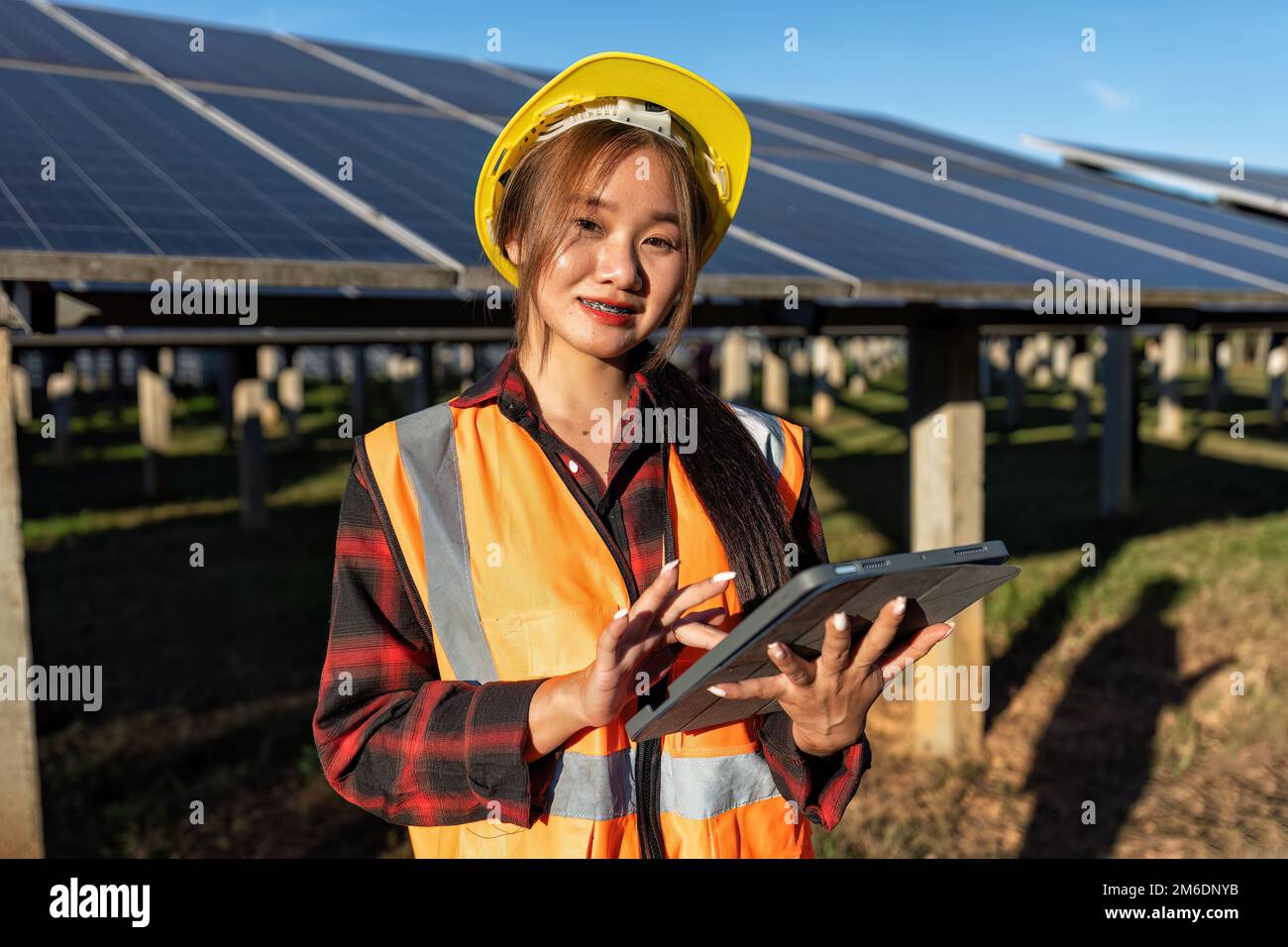 Maintenance engineer at greenery Solar farm at work hold tablet ...