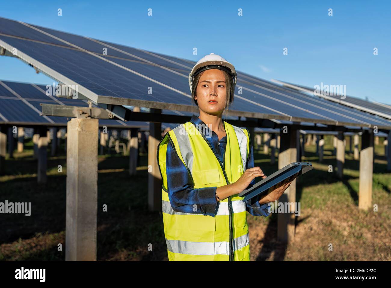 Maintenance engineer at greenery Solar farm at work hold tablet ...