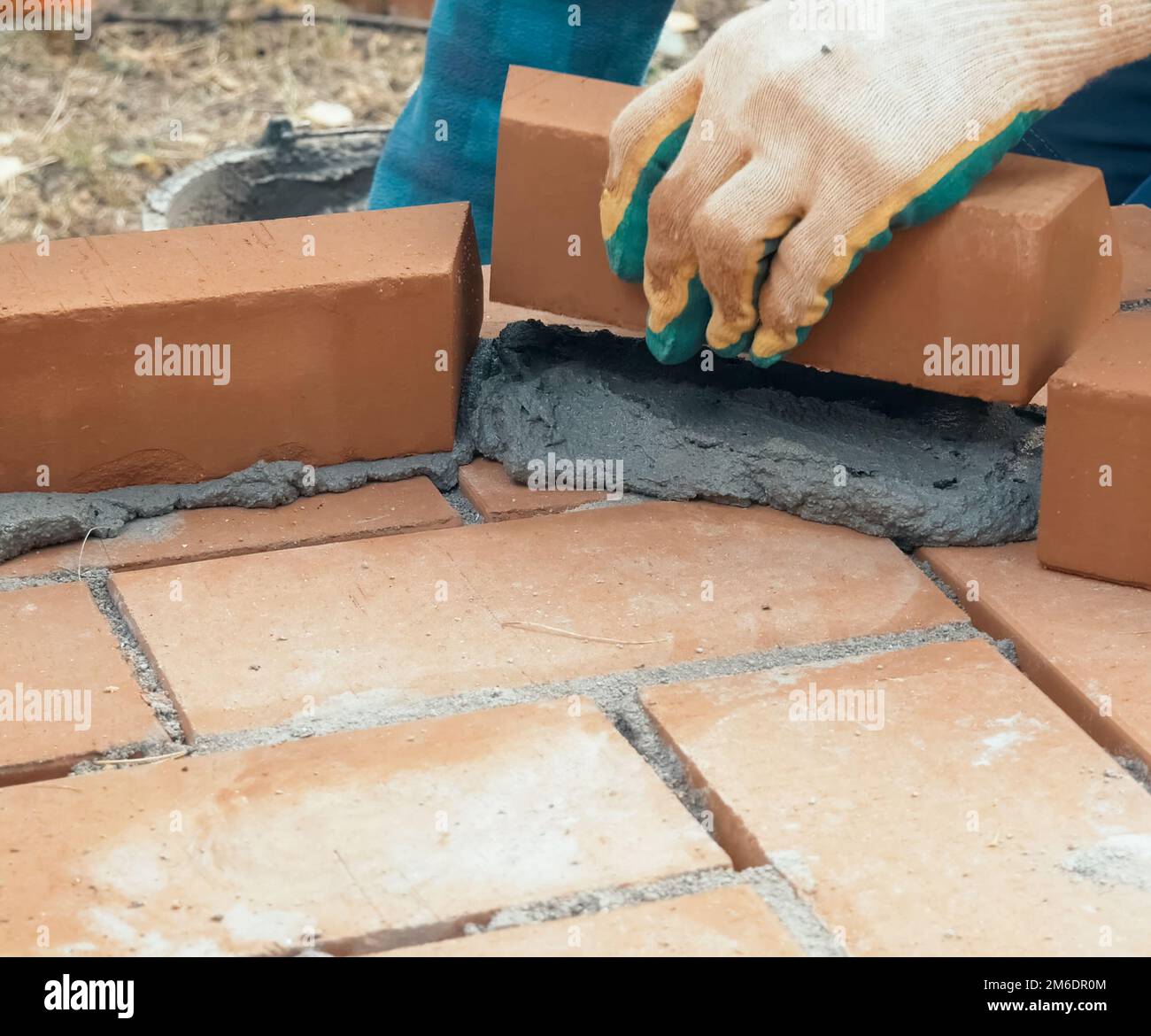 A man builds a brick wall. Brick put on the solution. Construction of ...