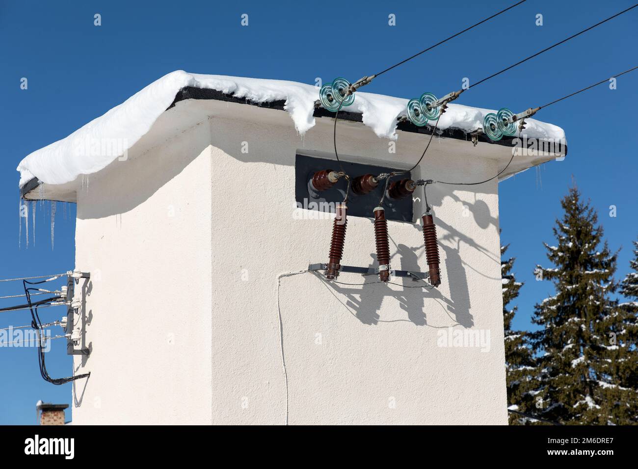 White snow on an electrical substation in nature. Glass insulator on ...