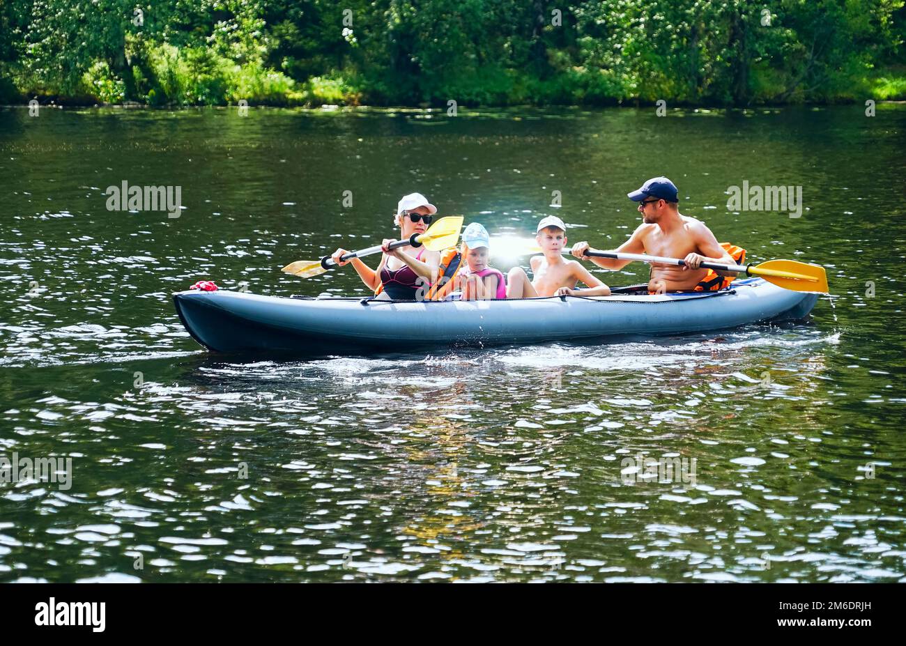 A young family with a son and daughter are kayaking on the lake Stock ...