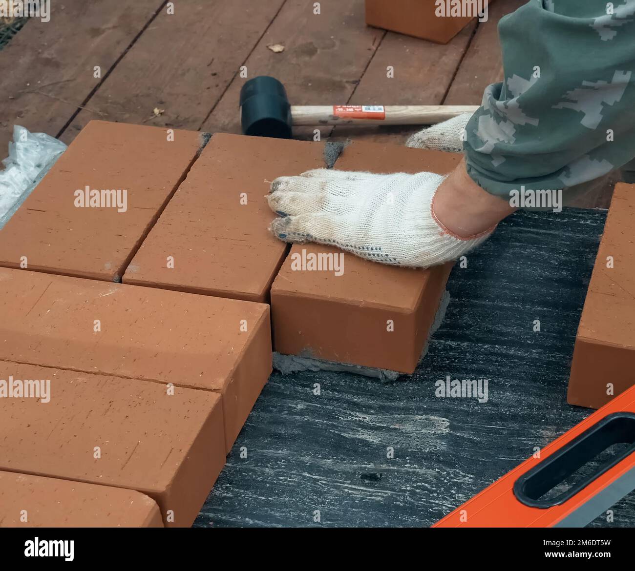 A man builds a brick wall. Brick put on the solution. Construction of ...