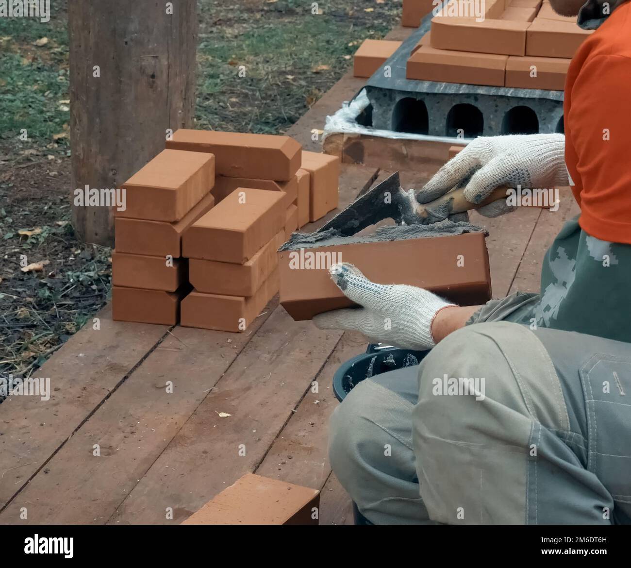 A man builds a brick wall. Brick put on the solution. Construction of ...