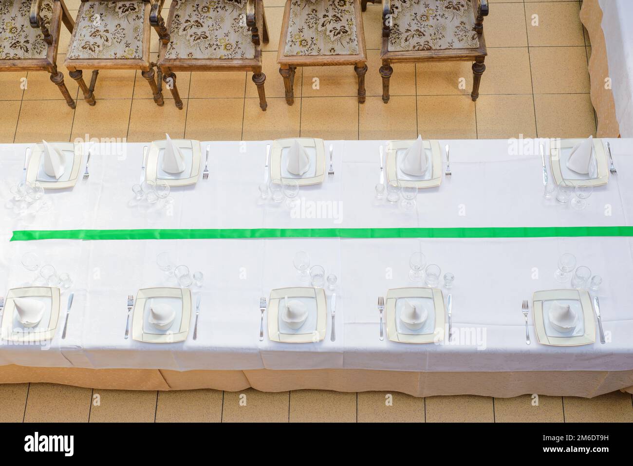 Aerial view to the long served table with plates, glasses, napkins and ...