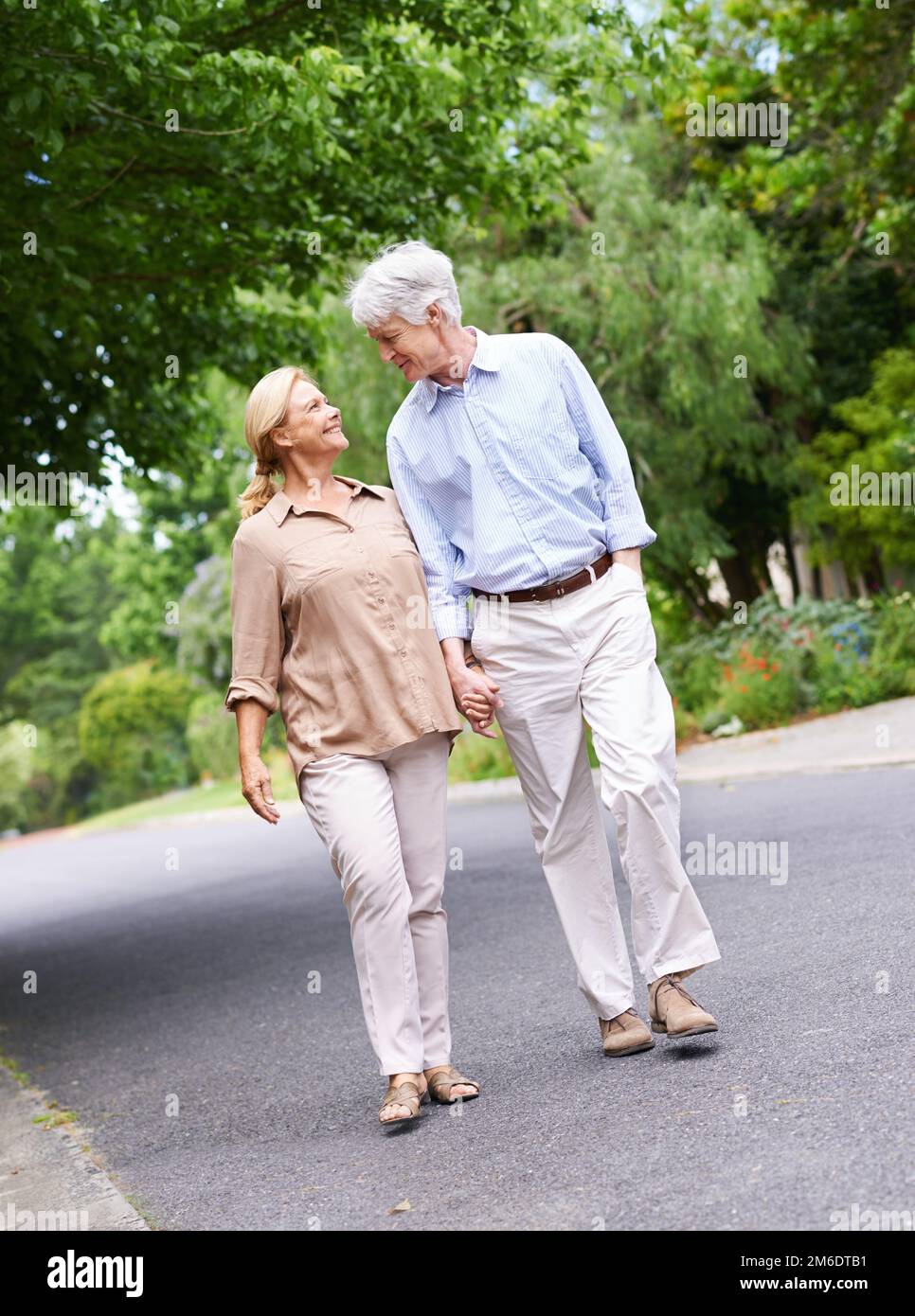 They still walk holding hands. an affectionate senior couple talking a walk Stock Photo - Alamy