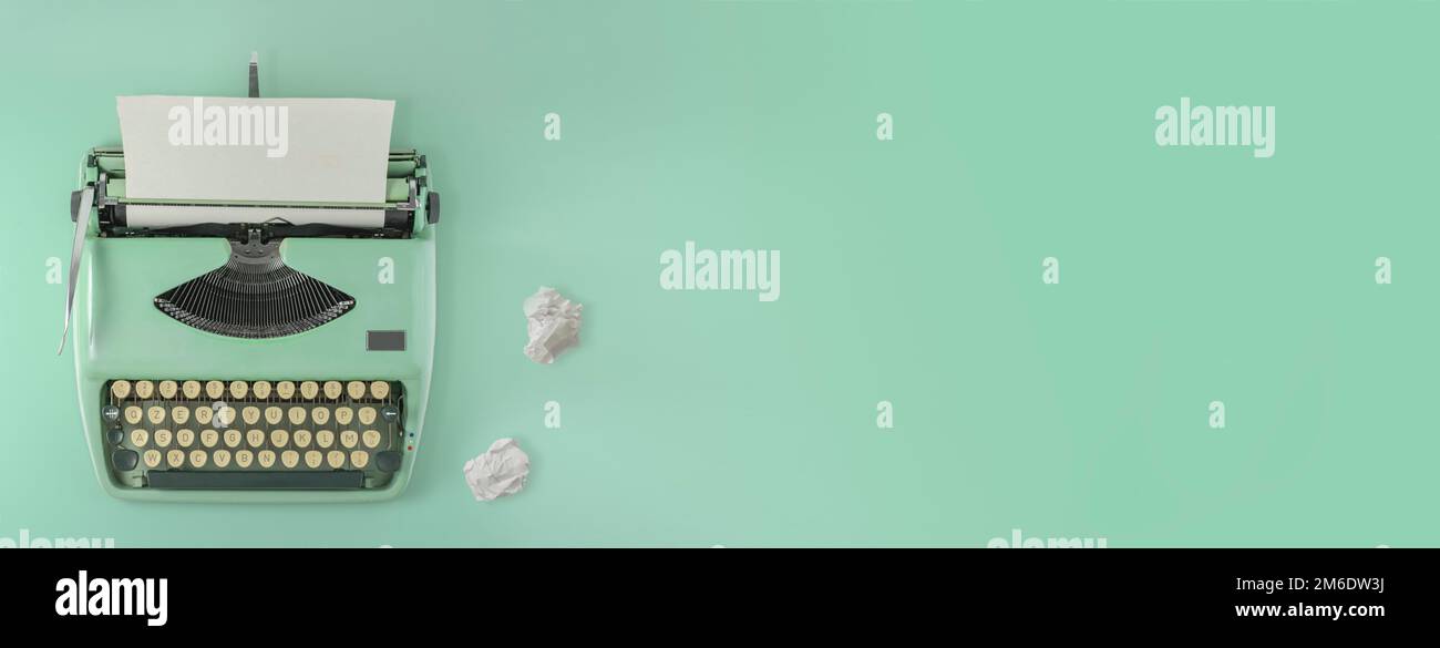 A green vintage typewriter with two paper balls Stock Photo - Alamy