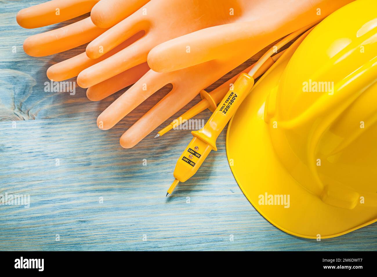 Electric tester insulating gloves building helmet on wooden board ...