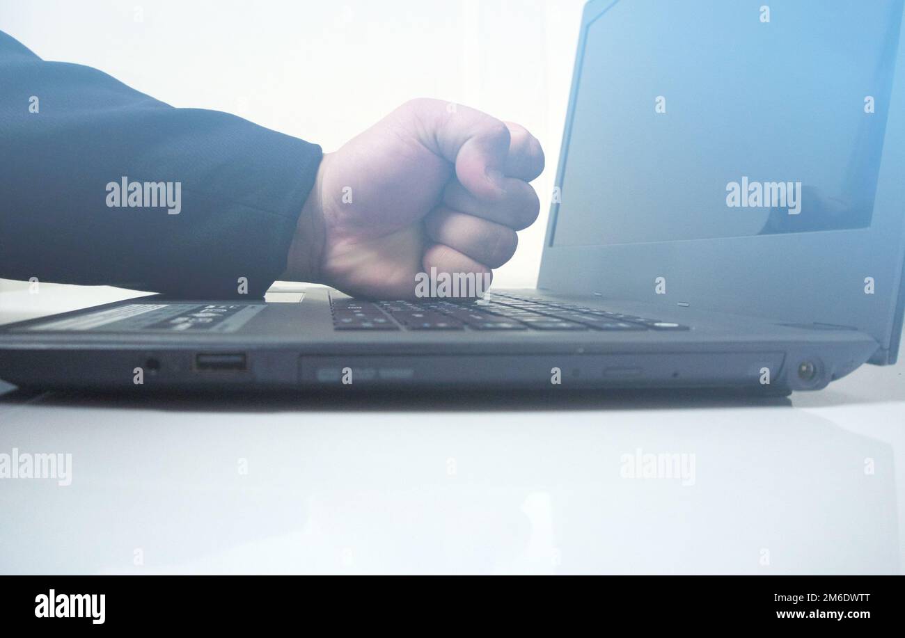 Problems of laptops at work. Office upset from work. Fists smashing ...