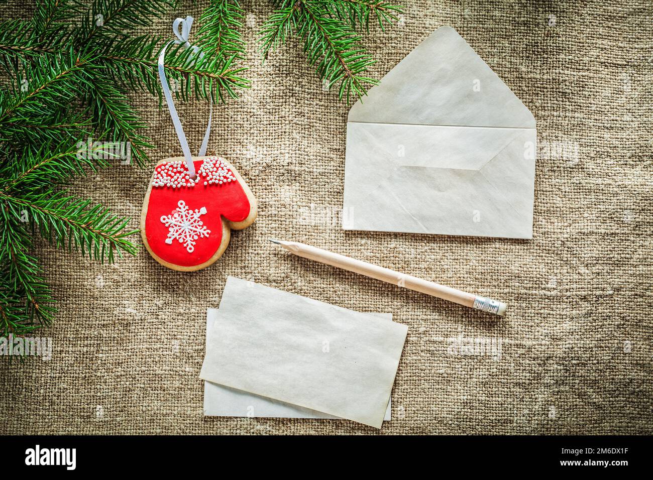 Fir tree branch envelope paper pencil gingerbread on sacking background ...