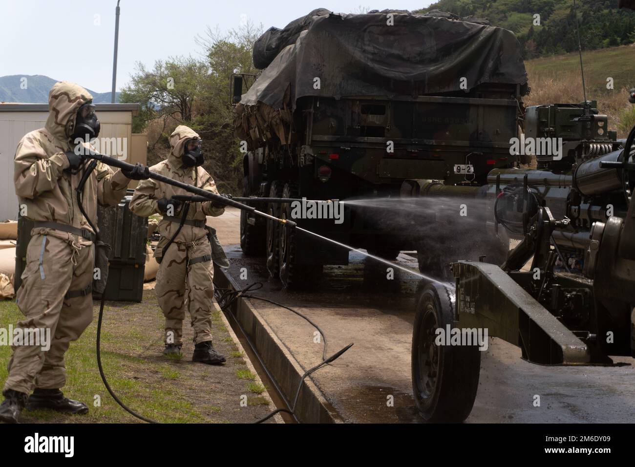 U.S. Marines assigned to 3d Battalion, 12th Marines, 3d Marine Division decontaminate an M777 ...