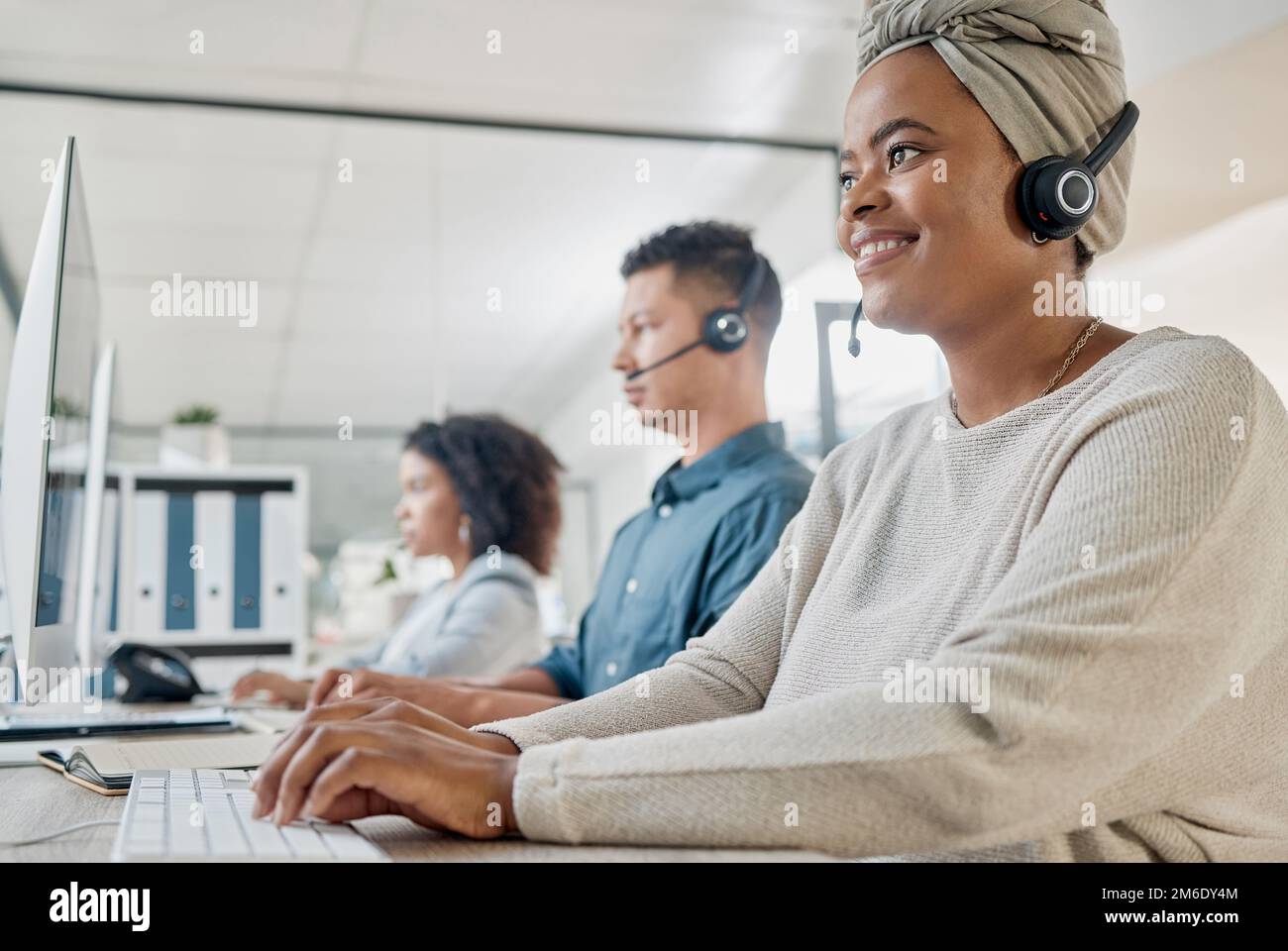 Black woman, call center consultant and contact us with CRM and happy employee at desk with ...