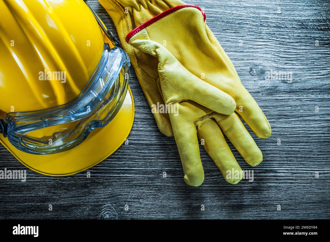 Safety gloves hard hat goggles on vintage wooden board Stock Photo - Alamy