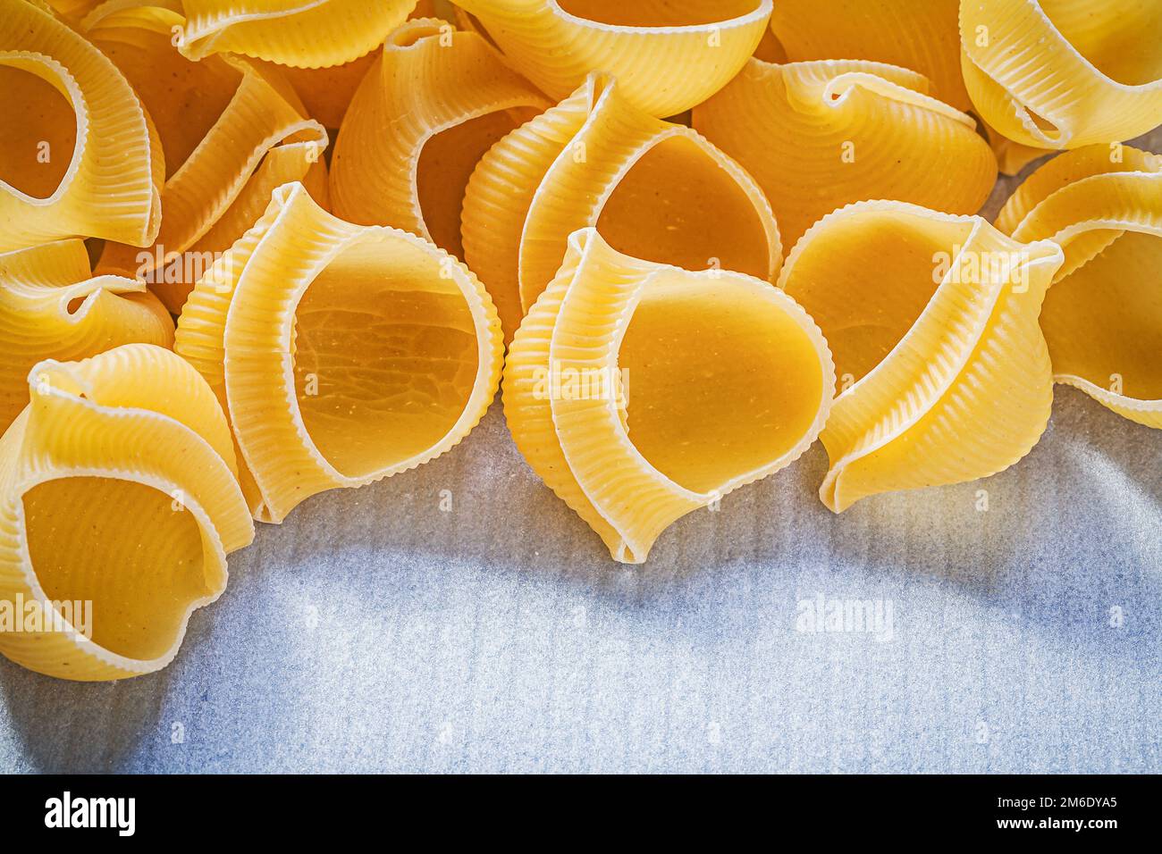 Stack of shell macaroni on blue background food and drink concept Stock ...