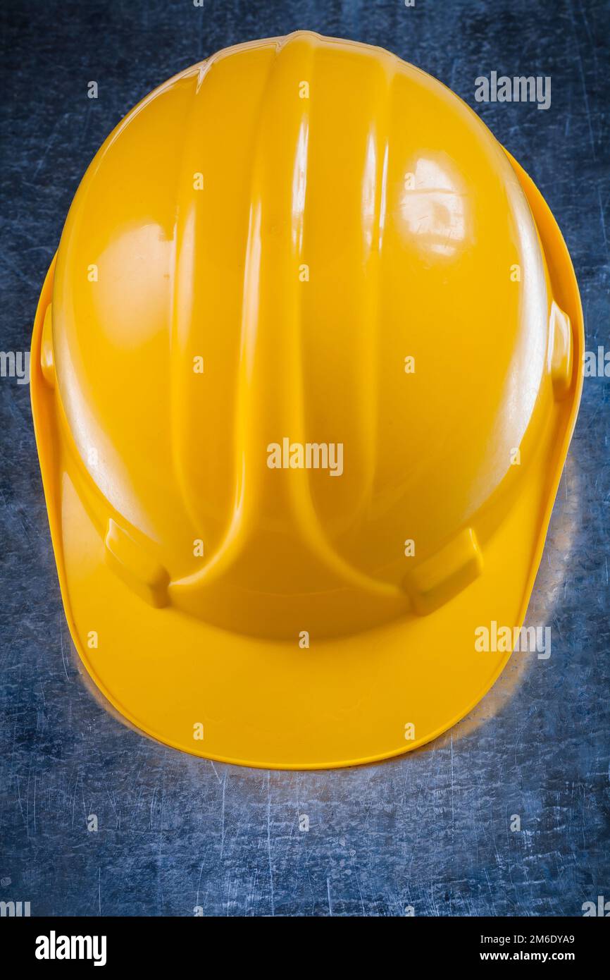 Yellow protective building helmet on scratched vintage metallic ...