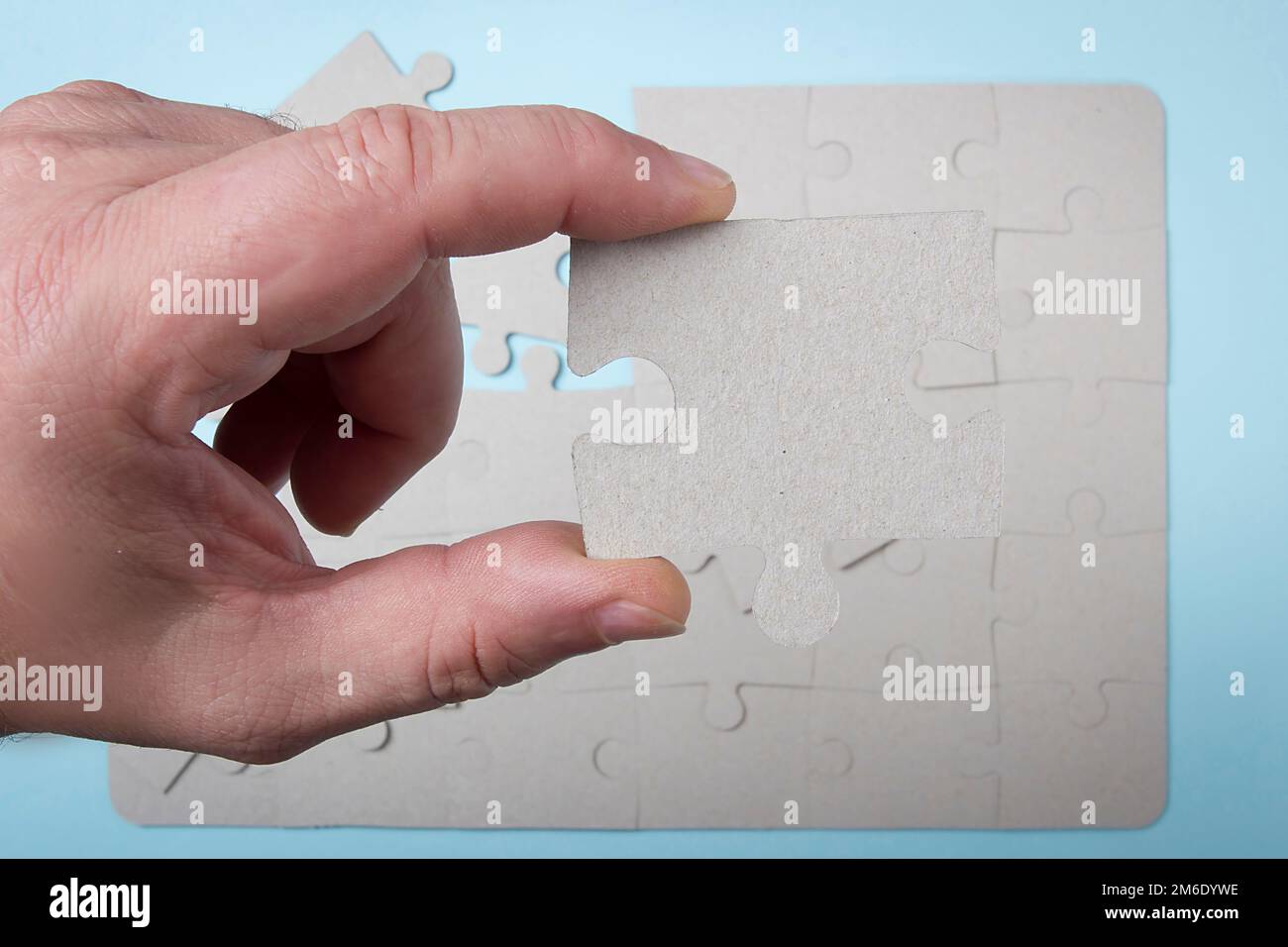 Hand adds puzzle Stock Photo - Alamy