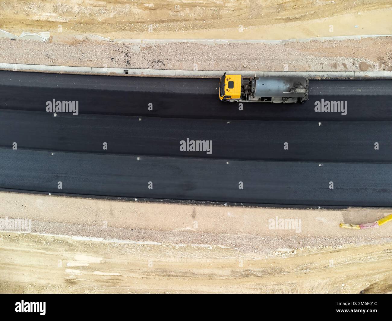 yellow truck pouring bitumen over a new road. Aerial drone shot. Road ...