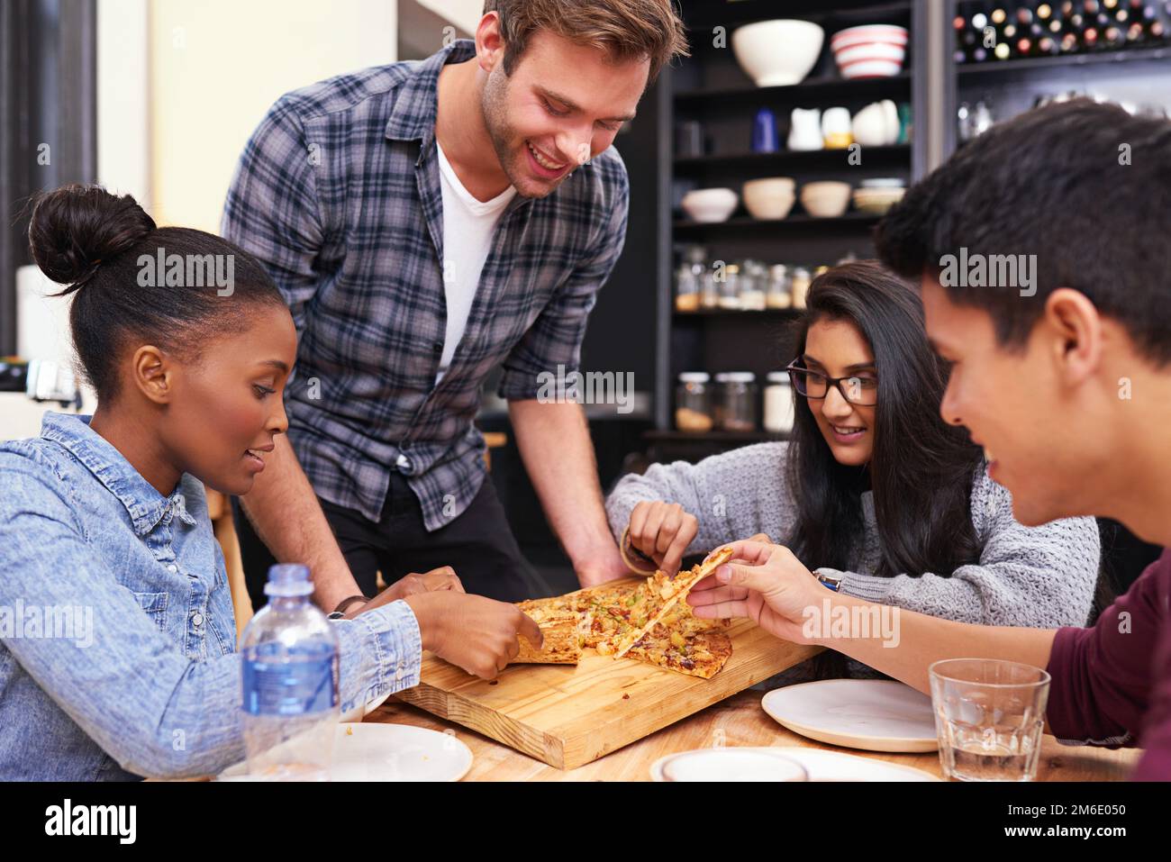 Take a slice. a group of friends enjoying pizza together Stock Photo ...