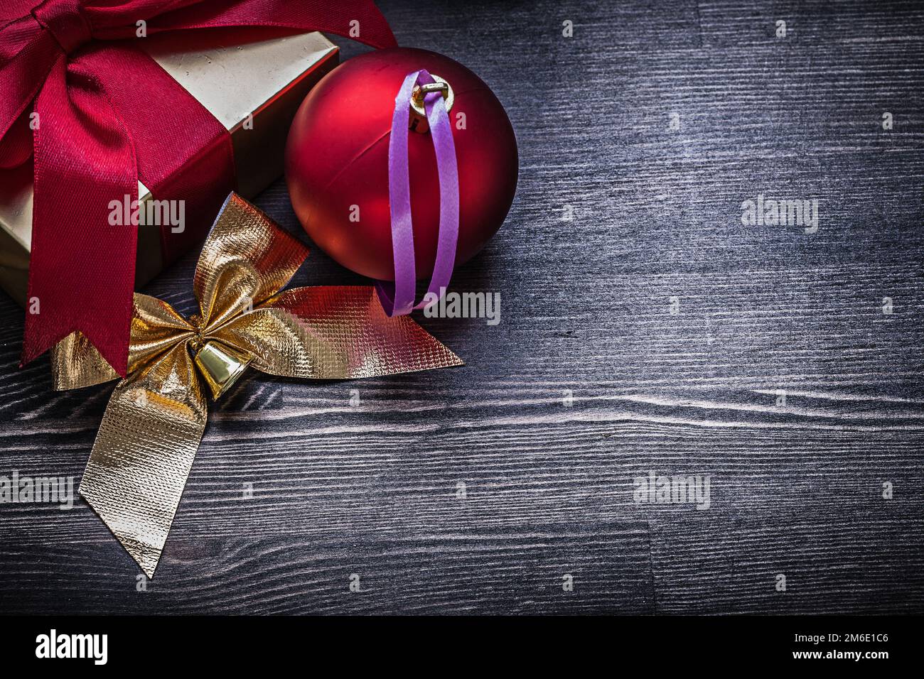 Composition of shining ball bow gift box on wooden board Stock Photo ...