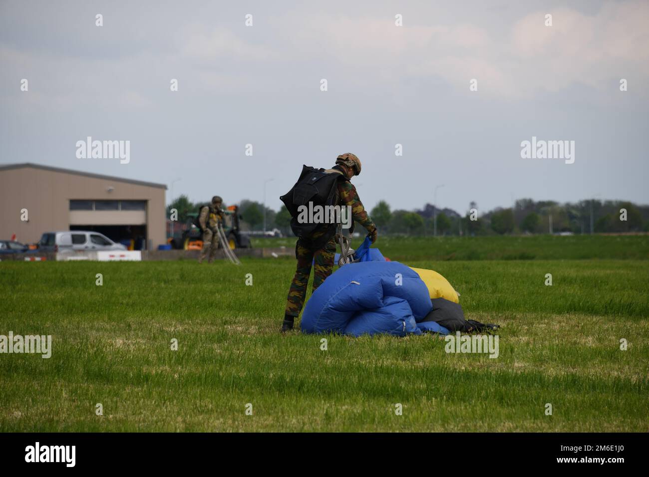 A Belgian paratrooper packs his parachute during sustainment training ...