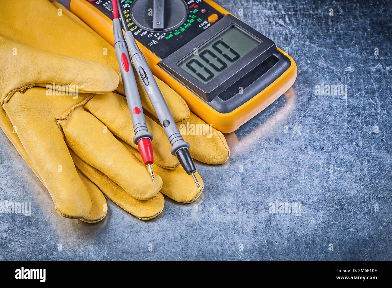 Digital electrical tester safety gloves on metallic background Stock ...