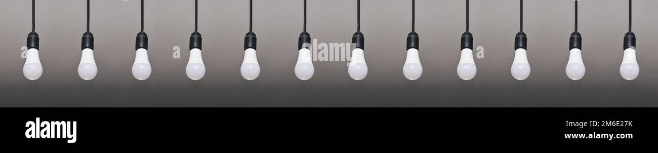 banner of hanging LED lamps on wires. energy efficiency concept with ...