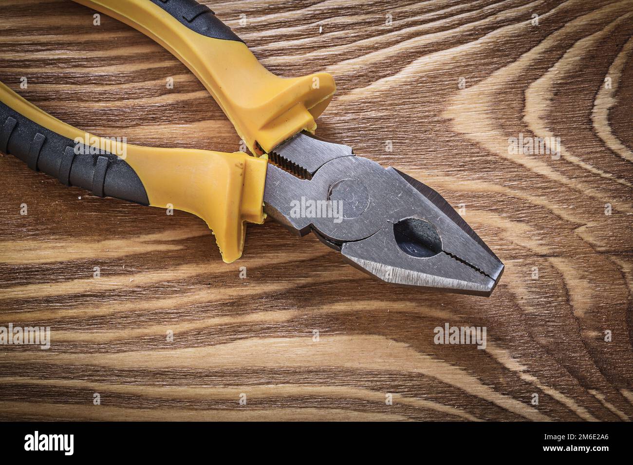 Gripping tongs on vintage wooden board directly above construction ...
