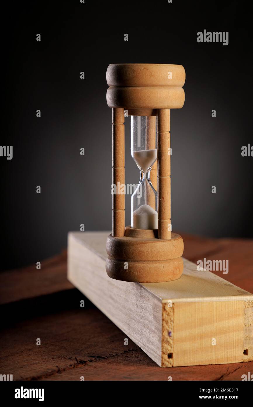Antique HourGlass Time on wood block with dark background Stock Photo ...
