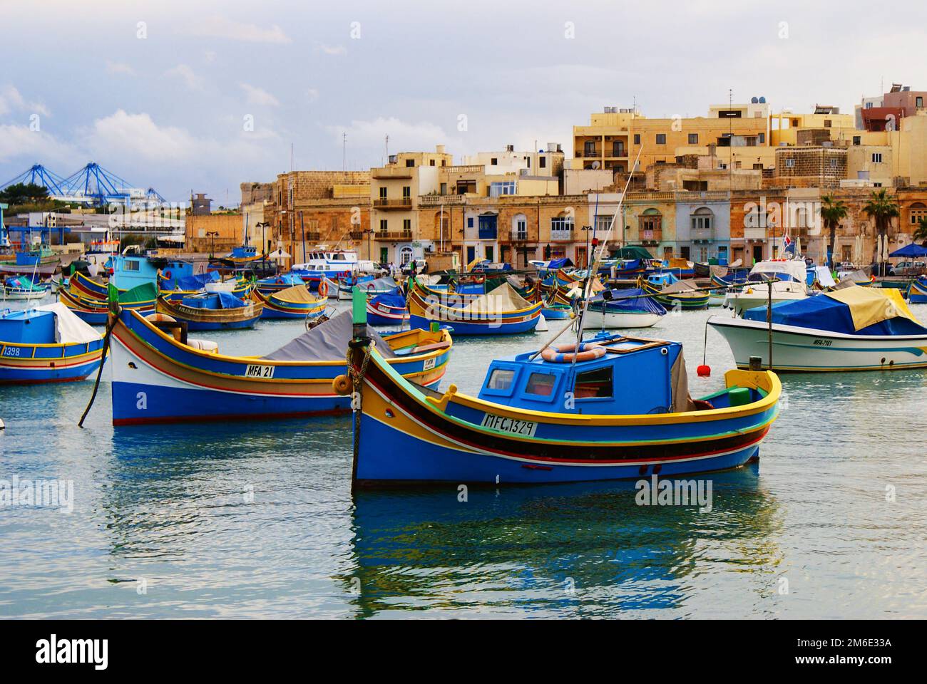 Traditional fishing boats luzzu in Marsaxlokk village in Malta, painted ...