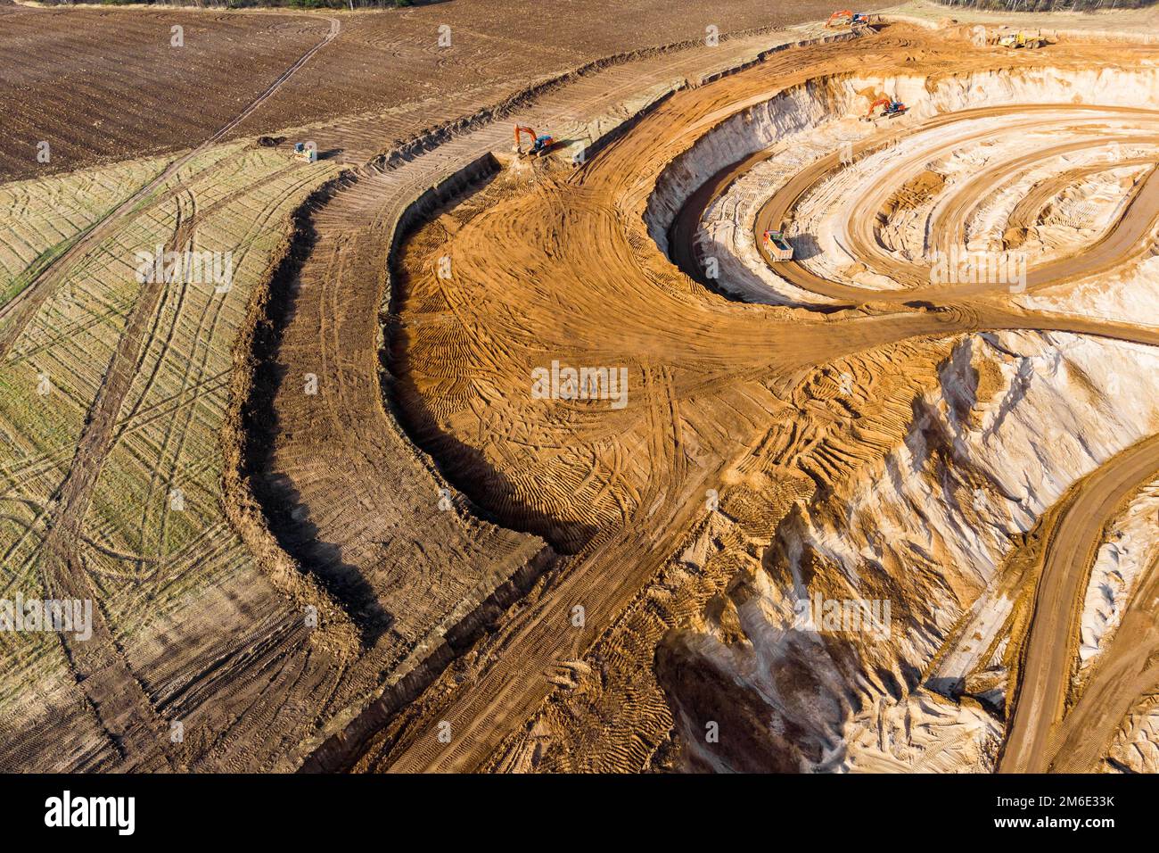 Aerial view of a growing sand pit at the expense of fields, overburden ...