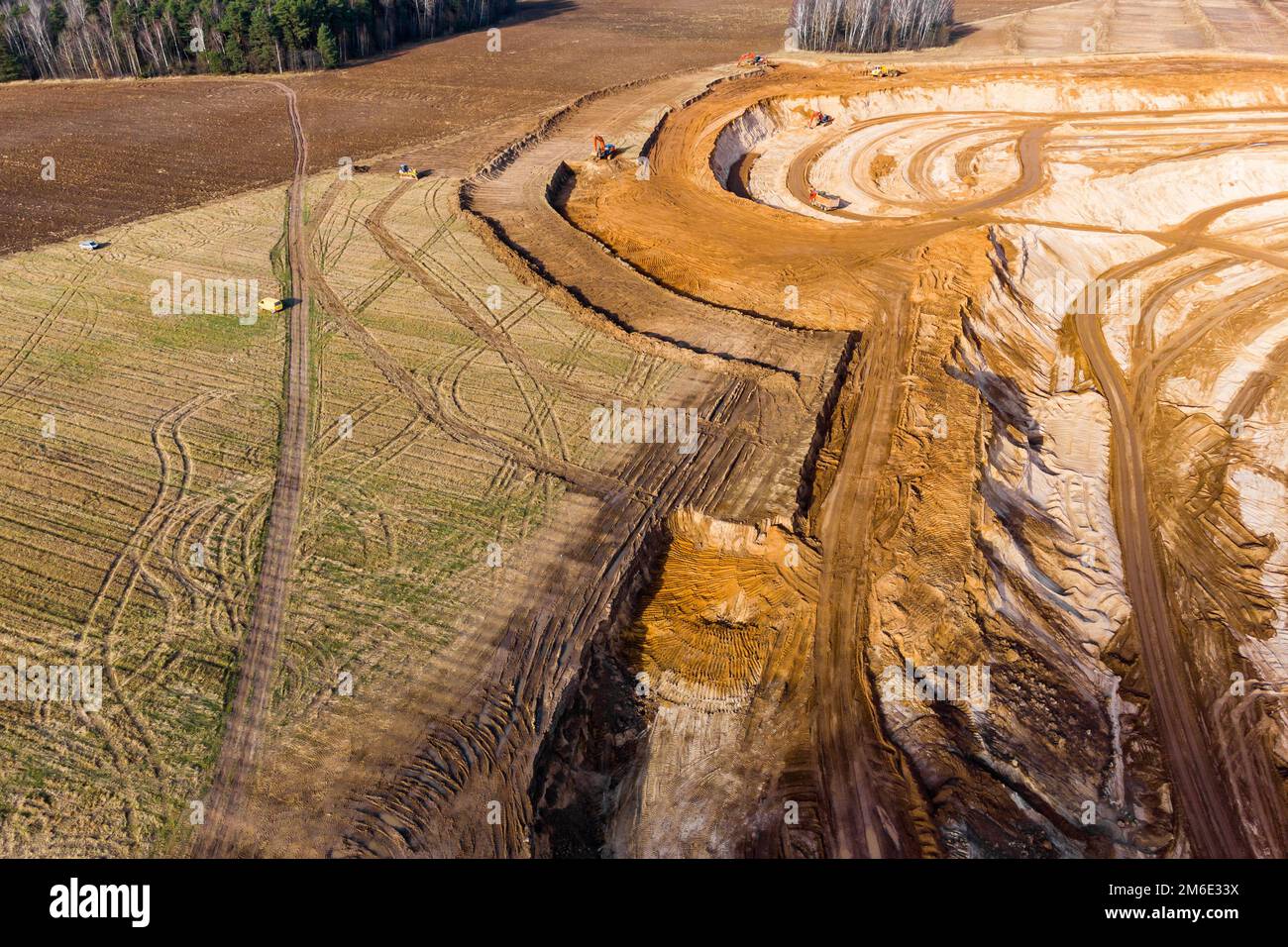 Aerial view of a growing sand pit at the expense of fields, overburden ...