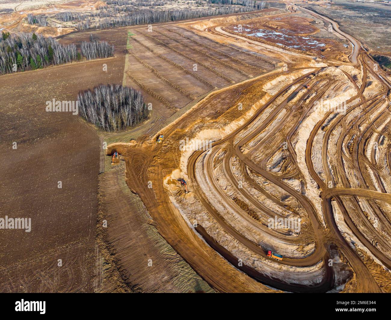 Aerial view of a growing sand pit at the expense of fields, overburden ...