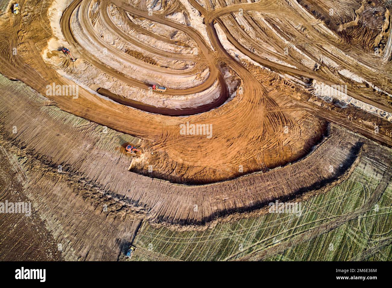 Aerial view of a growing sand pit at the expense of fields, overburden ...