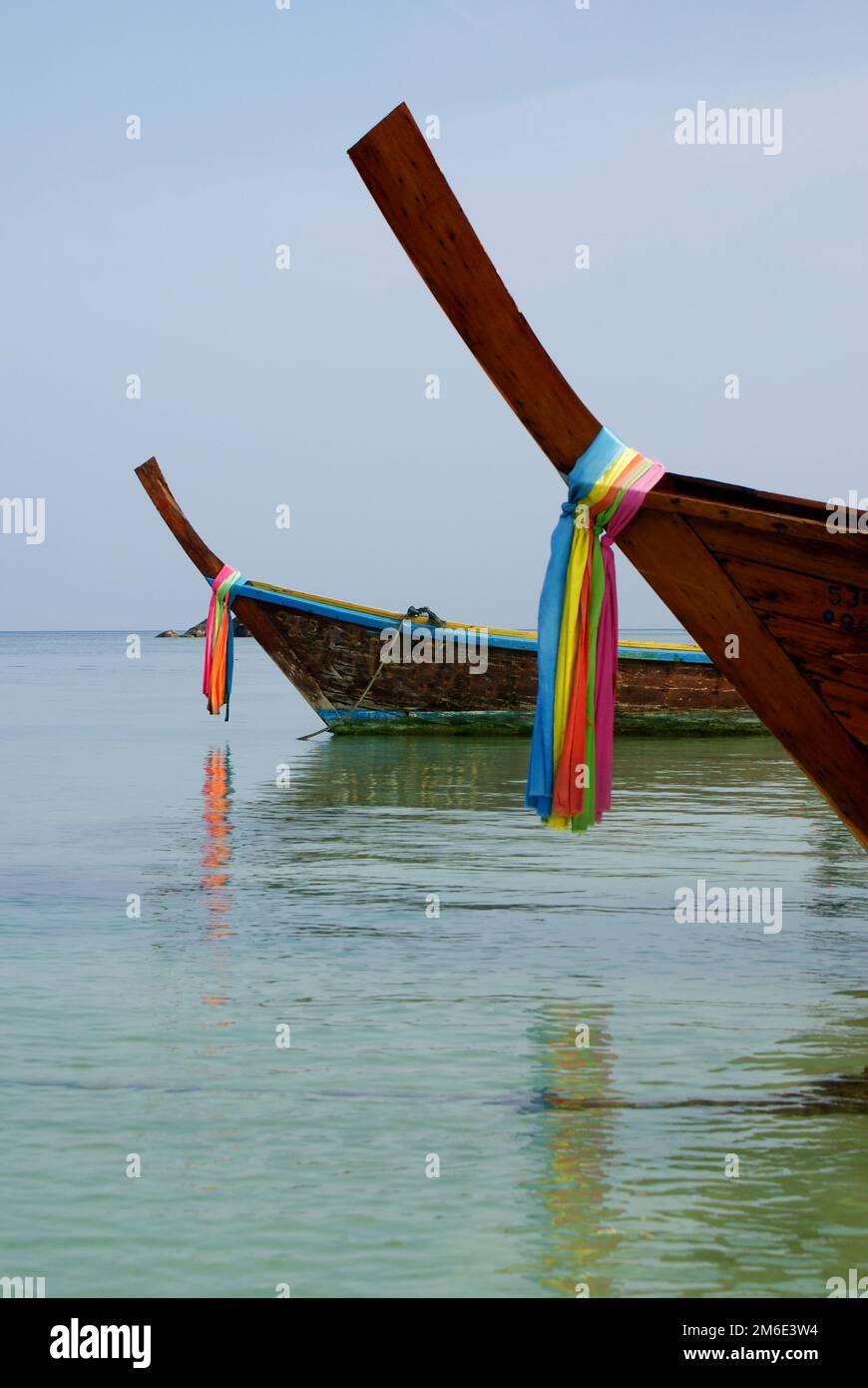 Wooden boats with colourful rainbow textile bands on the coast of Koh ...