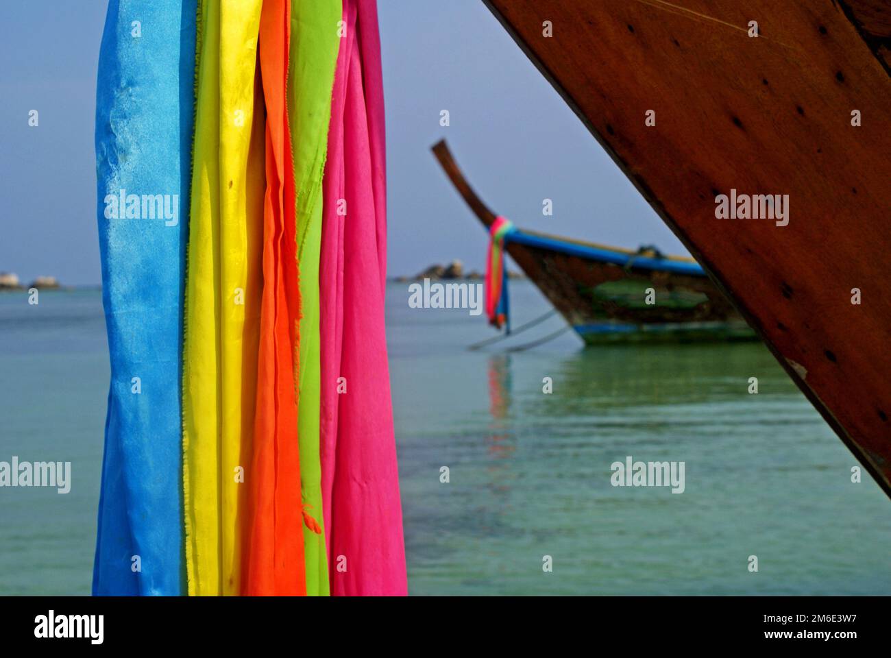 Wooden boats with colourful rainbow textile bands on the coast of Koh ...