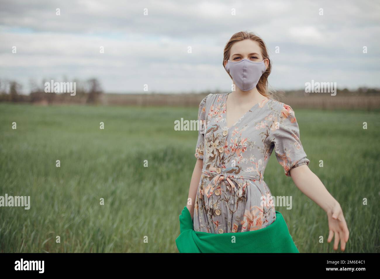 Young woman in protective mask in field. Lady quarantine in the village ...