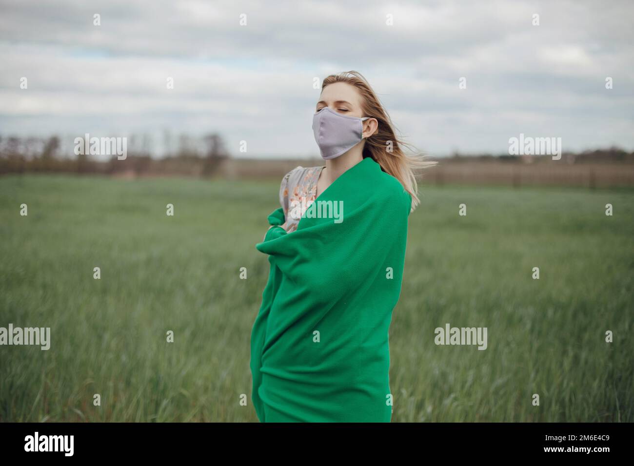 Young woman in protective mask in field. Lady quarantine in the village ...