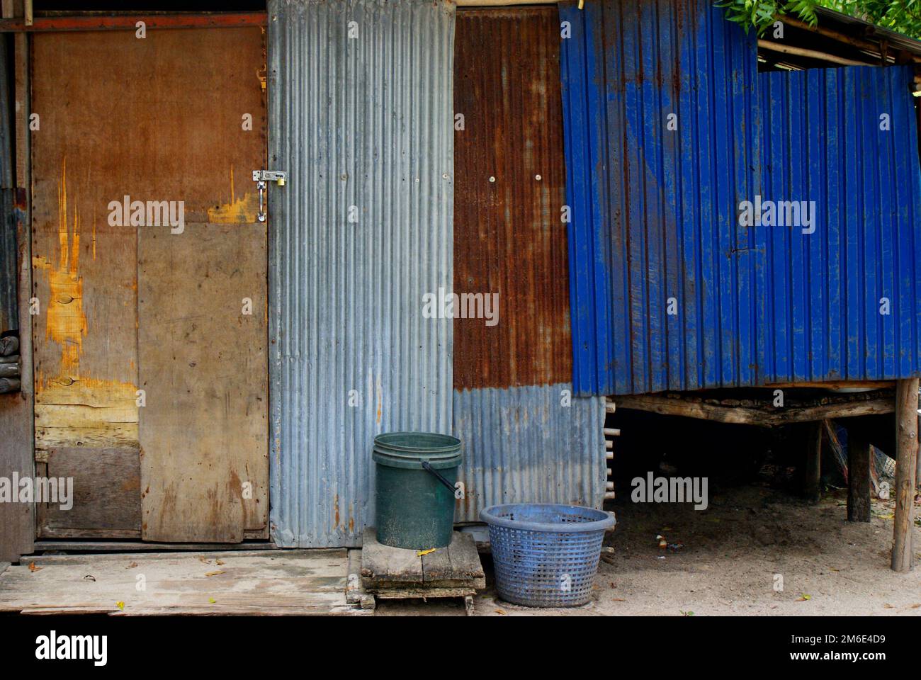 Colourful plastic barrels in front of a metal wall, background with ...